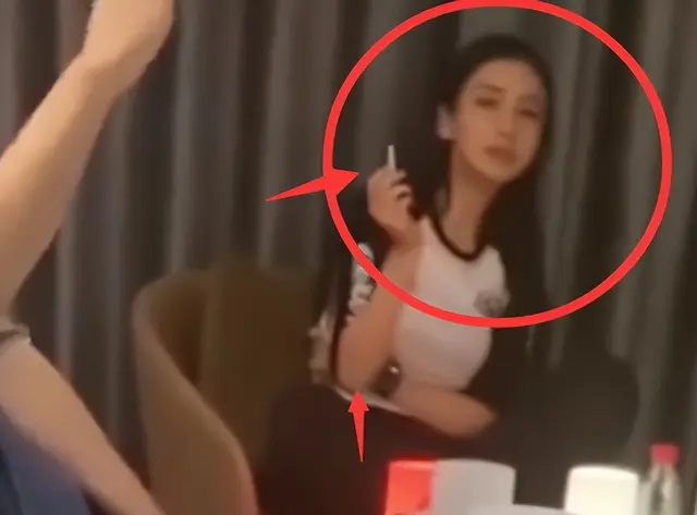 01 Angelababy sat casually, with her left arm resting on her right waist, smoking a cigarette ...